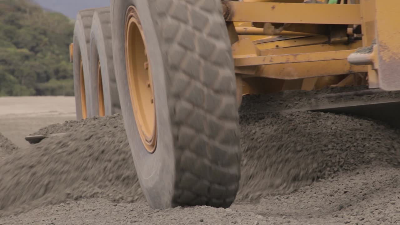 Wheels of a tractor in a construction site pulling sand and gravel ...