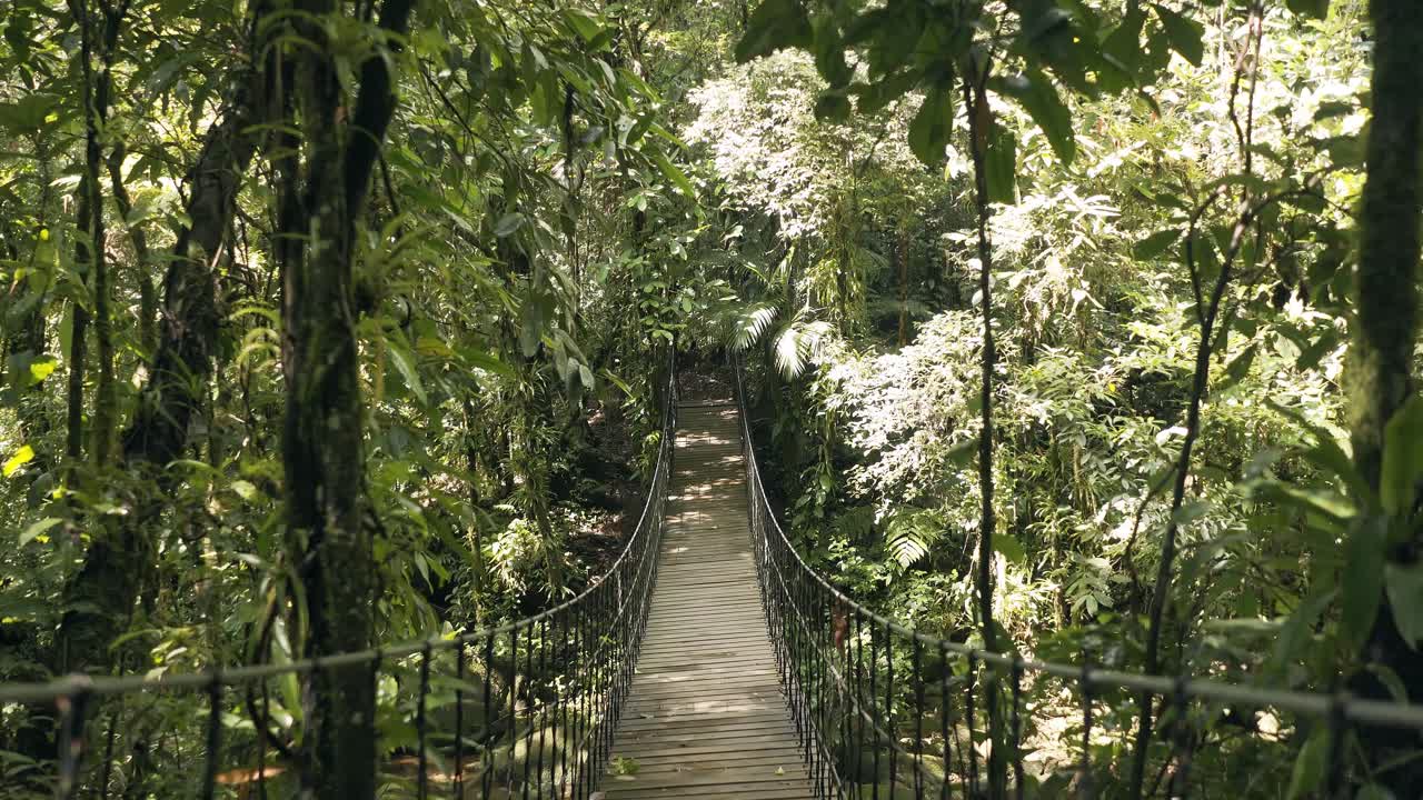 Premium stock video - Suspension wooden bridge across a river stream in ...