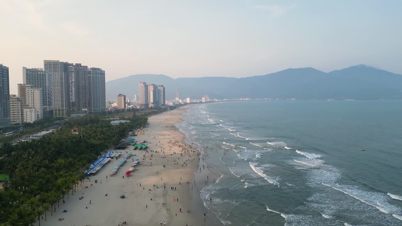 Aerial panoramic rise above Da Nang beachfront, showing coastline, high ...