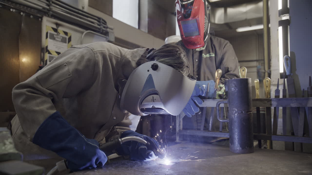 Premium stock video - Welders working together in a metal shop