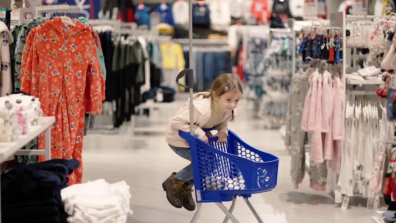 Premium stock video - Little girl is having fun in a clothes store ...