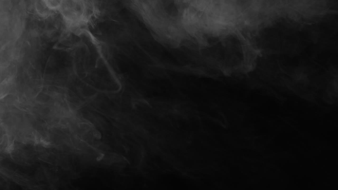 Static shot of dark, wispy fog provides a mysterious texture on a black ...
