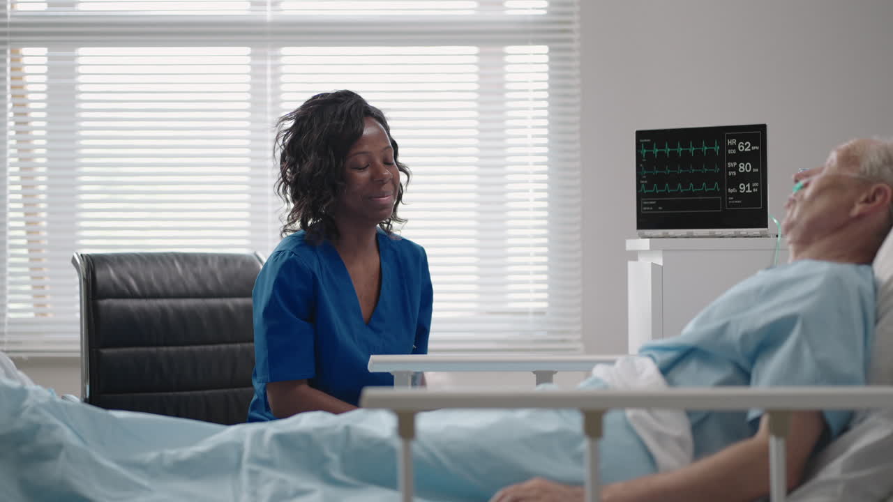 Premium stock video - A dark-skinned female doctor is talking to an old ...