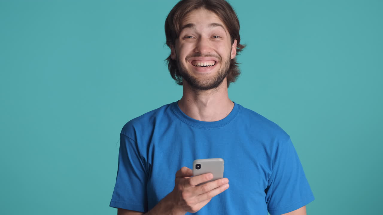 Free stock video - Caucasian man in front of camera on blue background.
