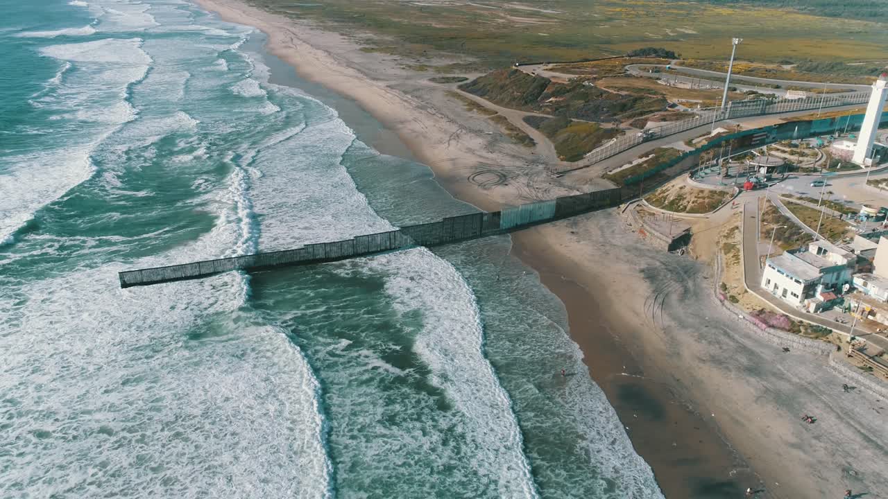 Aerial shot of the sea and beach of Tijuana with the wall of the border ...
