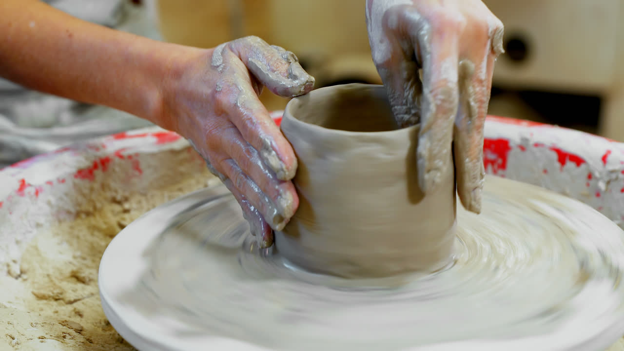 Premium stock video - Mid section of female potter molding clay 4k