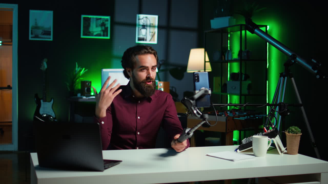 Expressive man using smartphone on selfie stick to shoot video Premium ...