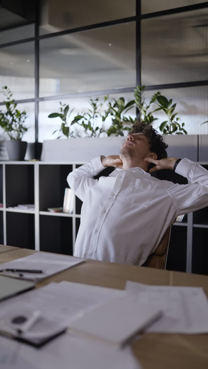 Man relaxing at his desk in a modern office. | Free Stock Video Footage