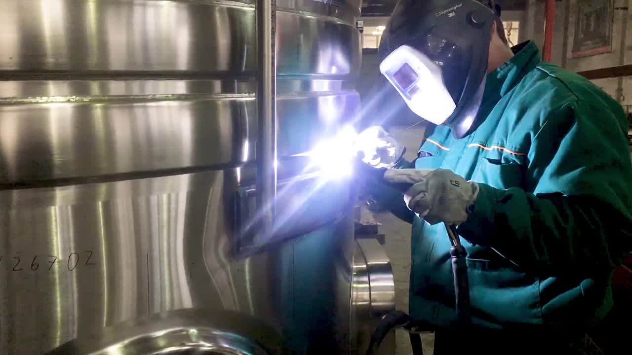 Premium stock video - Worker welding stainless steel tank, using tig ...