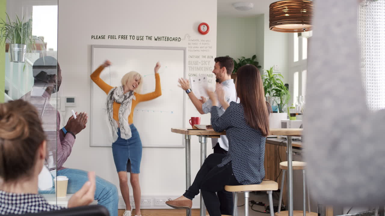 Crazy happy business woman dancing doing victory dance in team meeting ...