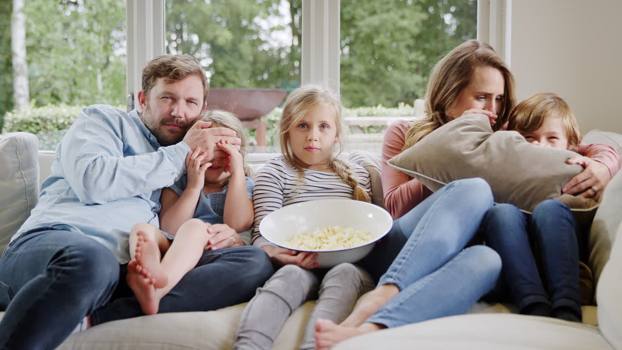 Premium stock video - Frightened family sitting on sofa at home ...