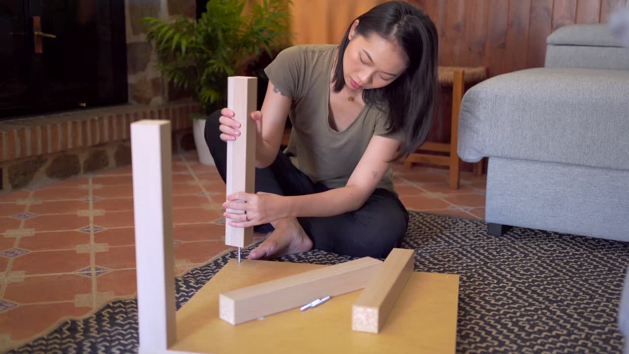 Premium stock video - Asian woman assembling table in living room