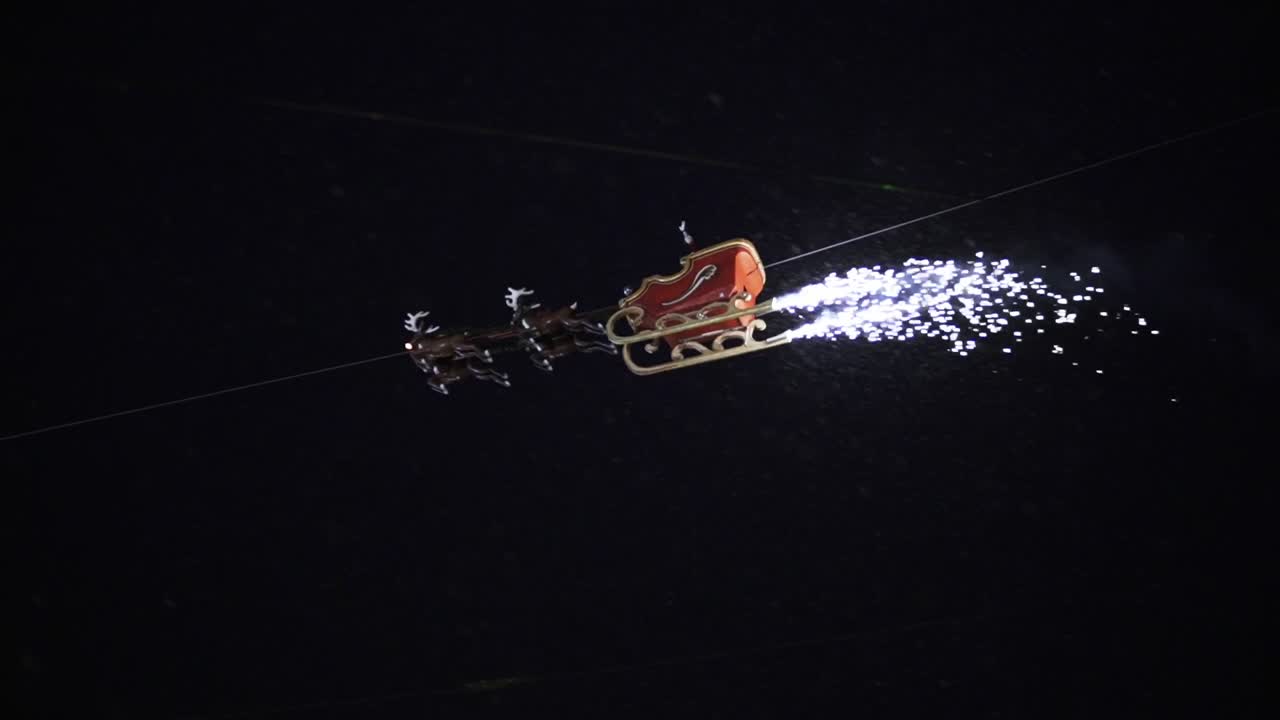Santa Claus flying over a christmas market with firework at a snowy ...