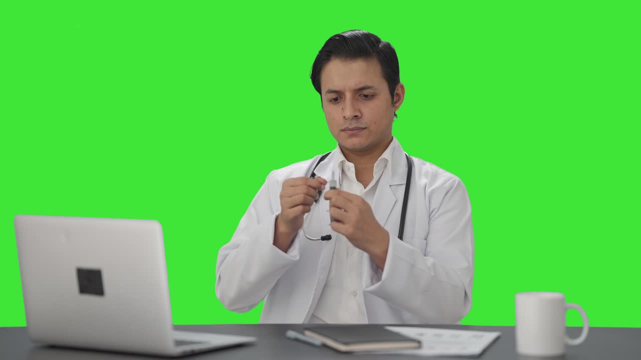 Premium stock video - Indian doctor filling the injection green screen