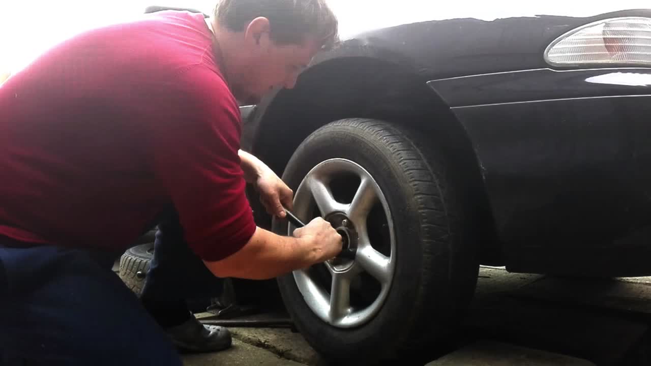 Man changing wheel for a car. time lapse Premium Stock Video Footage