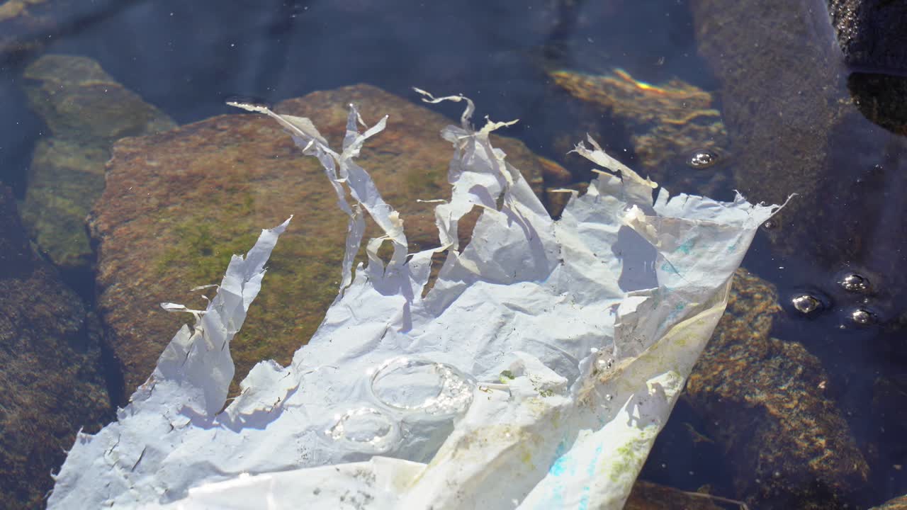 Close up of old plastic bag leaching microplastics into Norway fjord ...