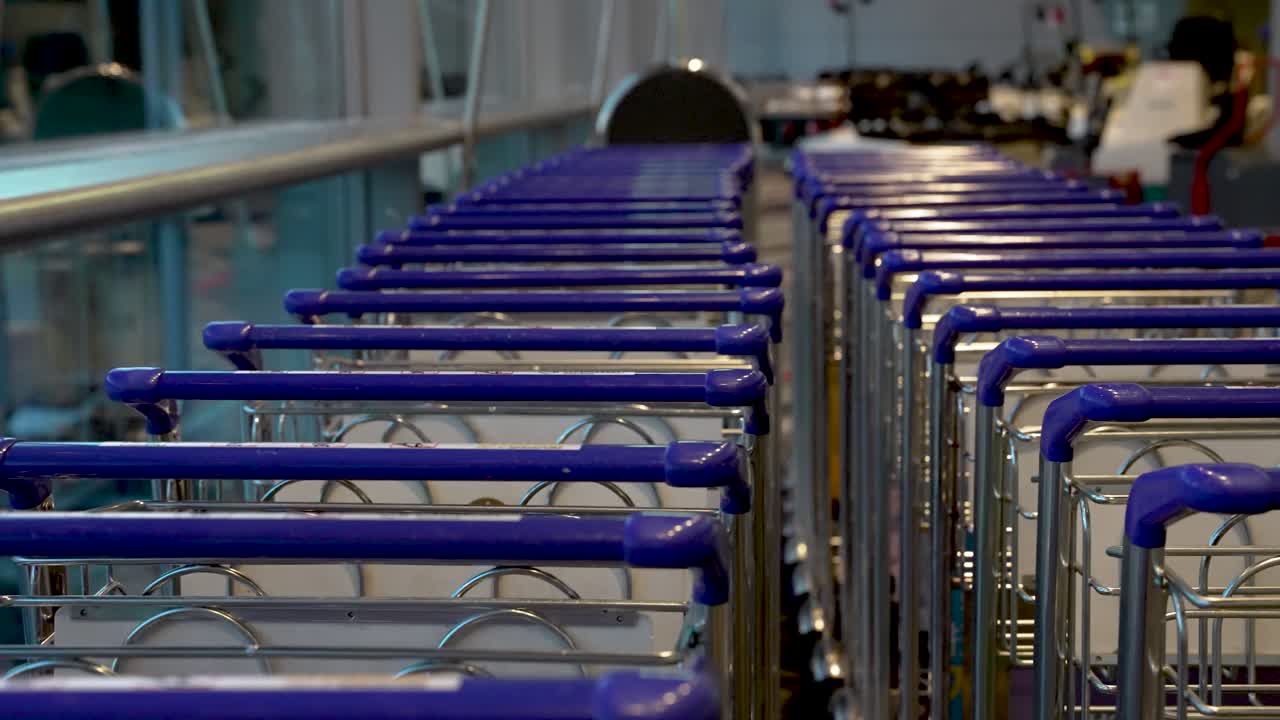 A row of luggage trolleys lock together in a single file for easy usage ...