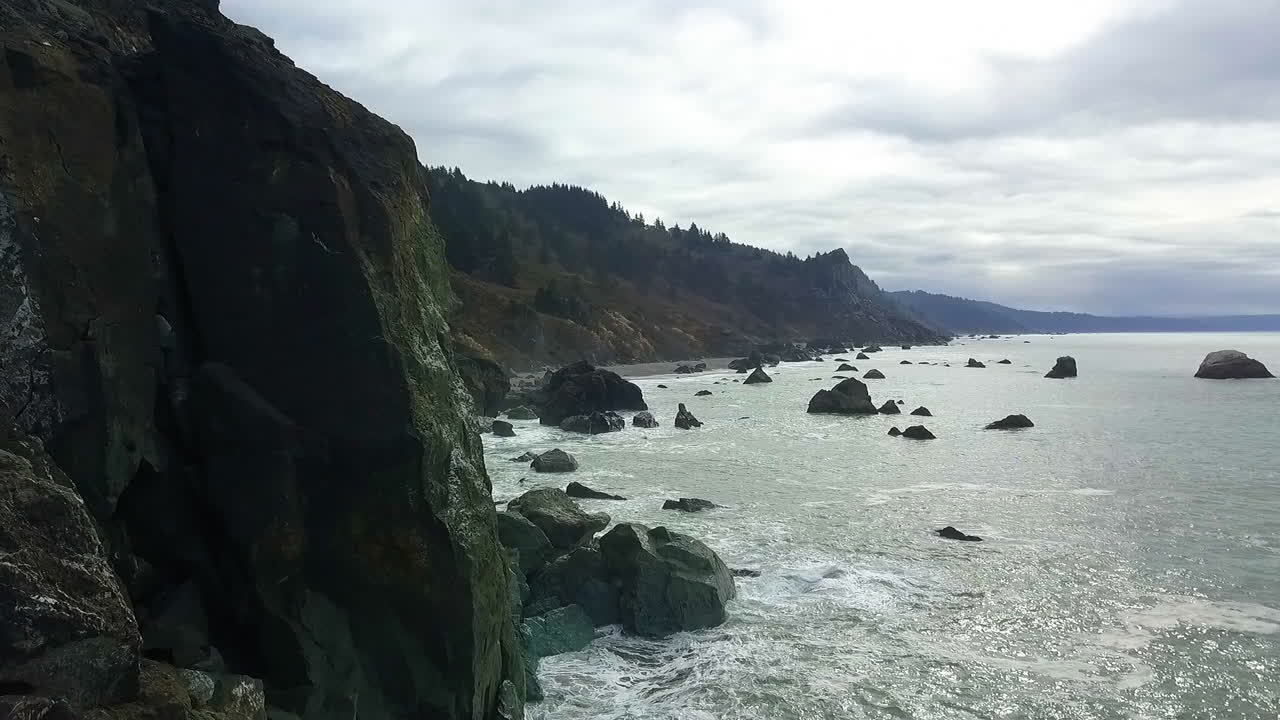 Drone Shot Of Cliffs And Rocky Ledges With Evergreens And Ocean ...