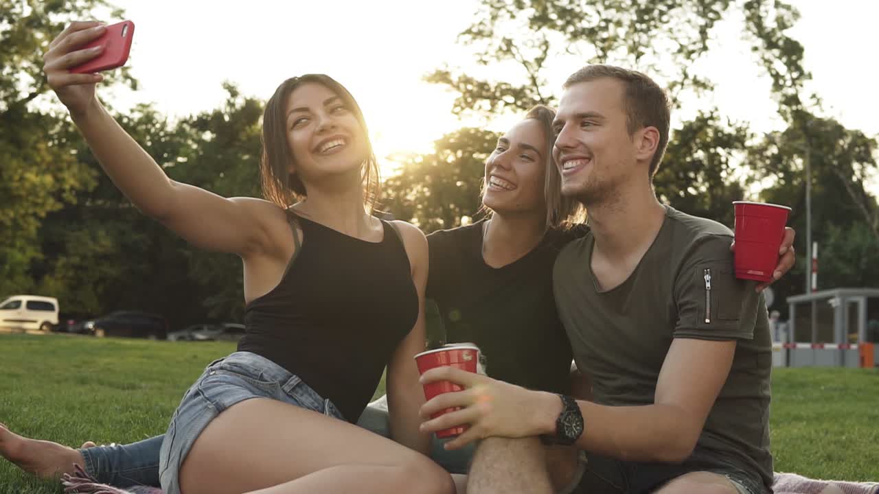 Free stock video - Portrait of three friends sitting on the grass in ...