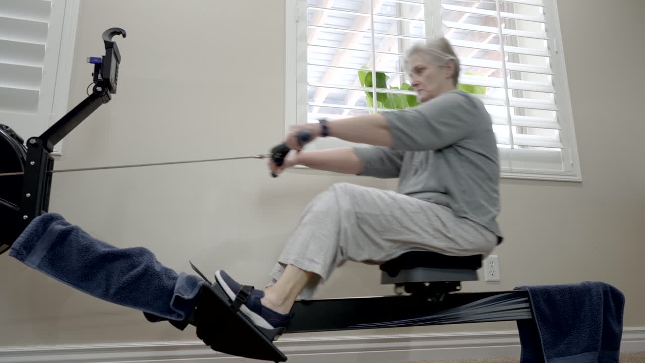 Vídeo de arquivo Premium - Mulher sênior exercitando em uma máquina de ...