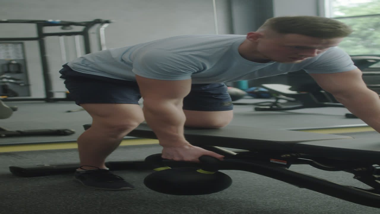 Man Doing Kettlebell Rows on Gym Bench | Premium Stock Video Footage