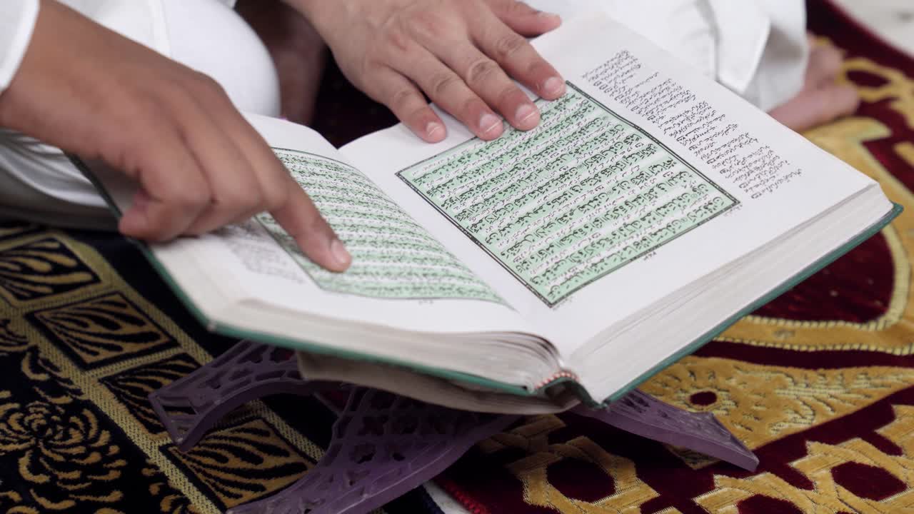 Premium stock video - Indian men reading quran holy book close up shot