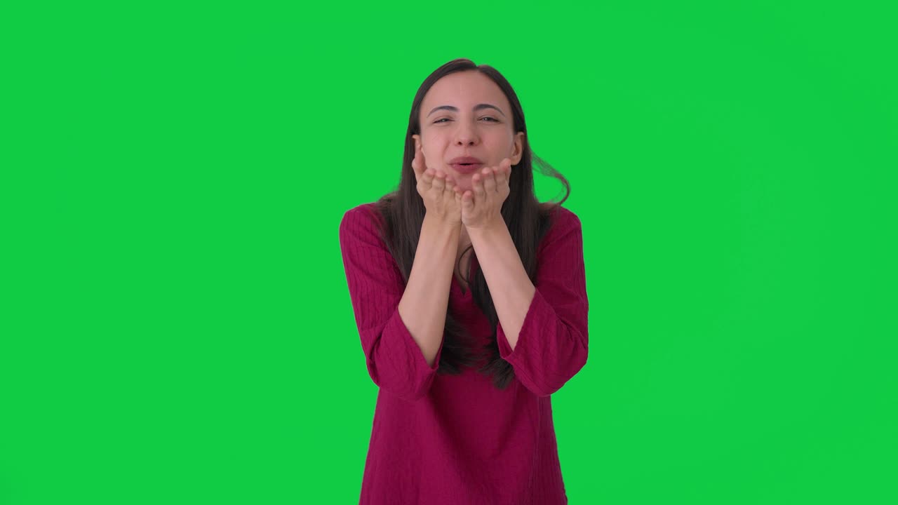 Premium stock video - Happy indian woman giving flying kisses green screen