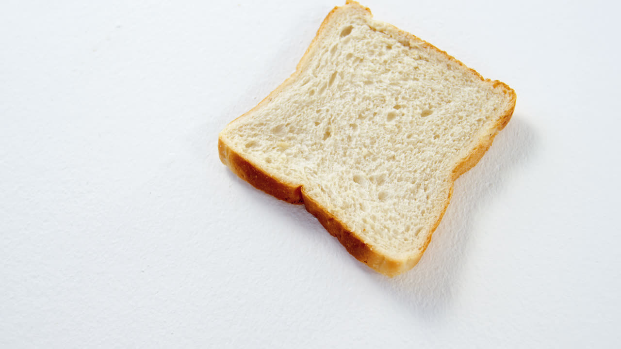 Premium stock video - Single bread slice on white background