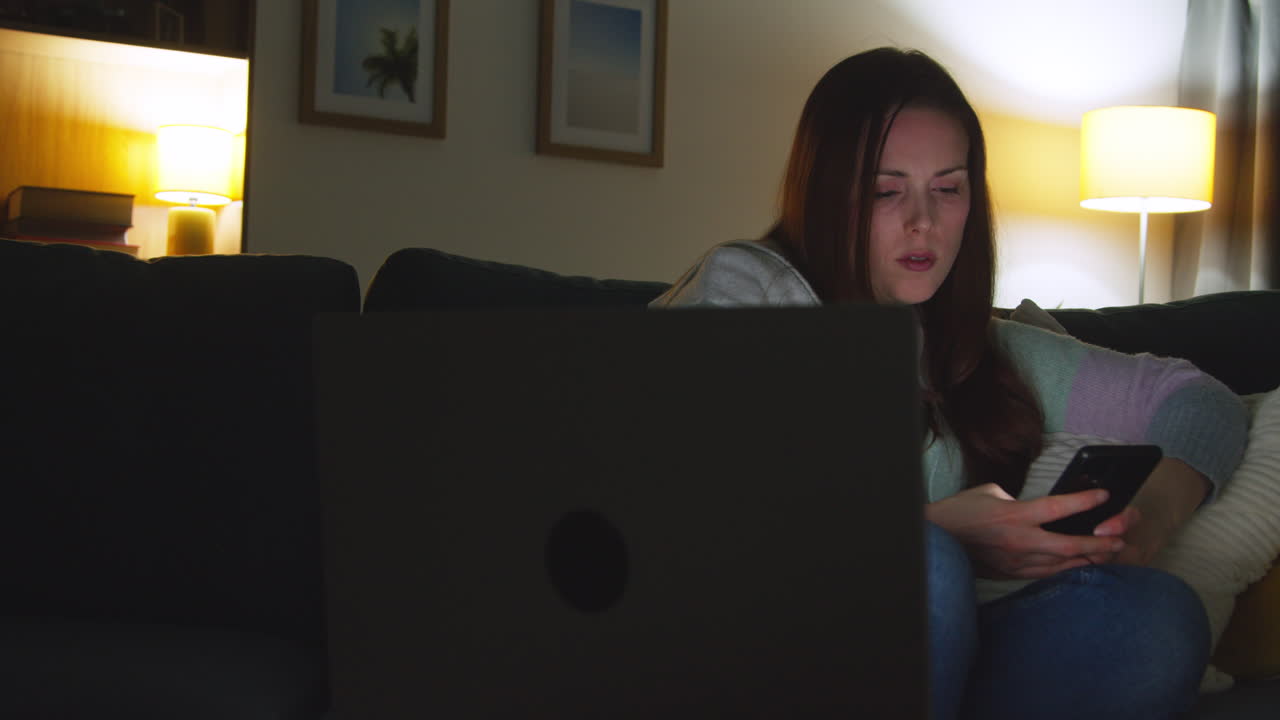 Woman Sitting On Sofa At Home At Night Streaming Or Watching Movie Or ...