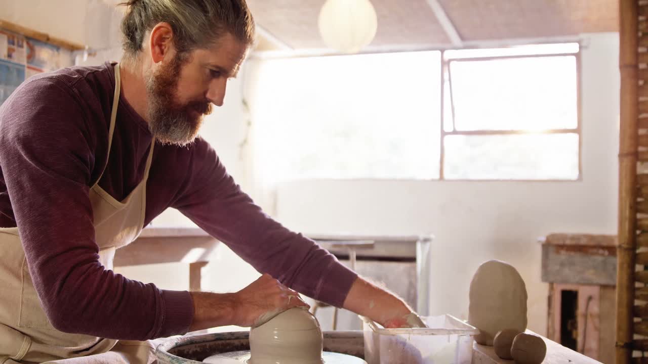 Premium stock video - Male potter making pot