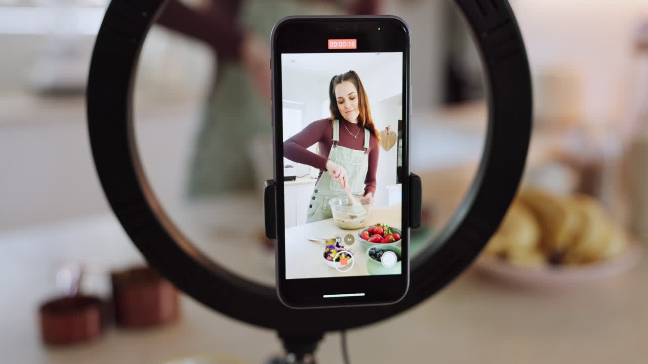 Premium stock video - Influencer woman, cooking and phone screen
