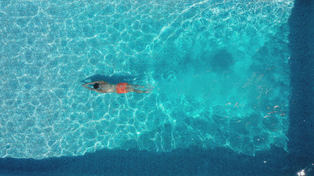 Premium stock video - Overhead drone shot of man diving into outdoor ...