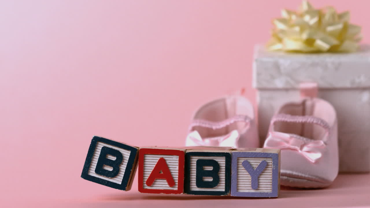 Premium stock video - Baby blocks toppling over with booties and gift ...
