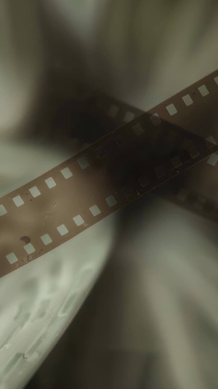 Vertical video: Sliding film strips after camera move, forming X on ...