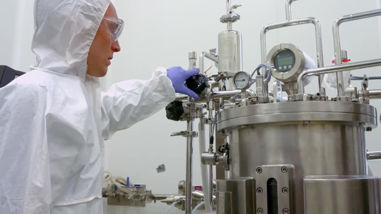 Premium stock video - Scientist in protective suits working on vat