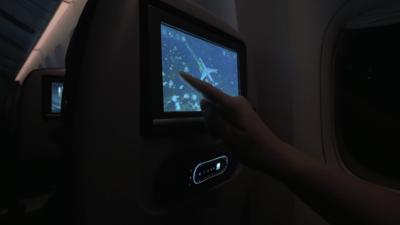 Premium stock video - Woman looking at flight path on touchscreen seat ...