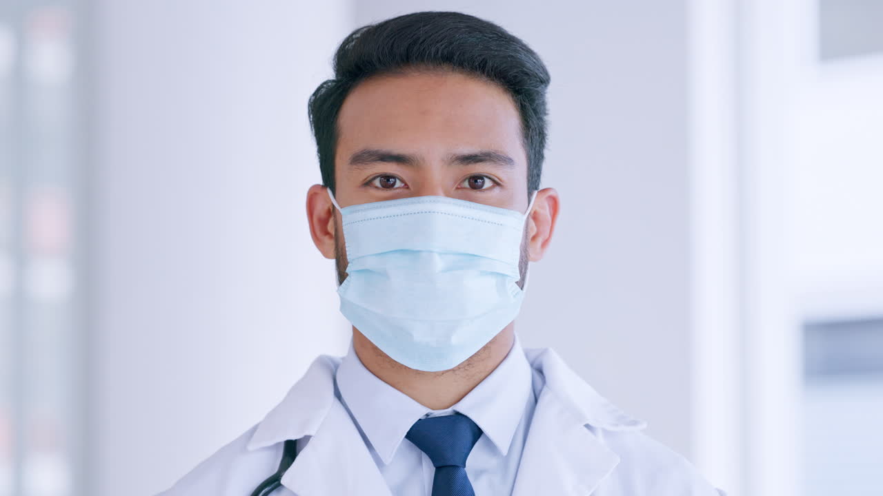 Premium stock video - Portrait of doctor taking face mask off as sign