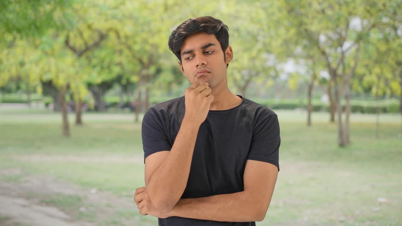 Premium stock video - Indian boy thinking in a park