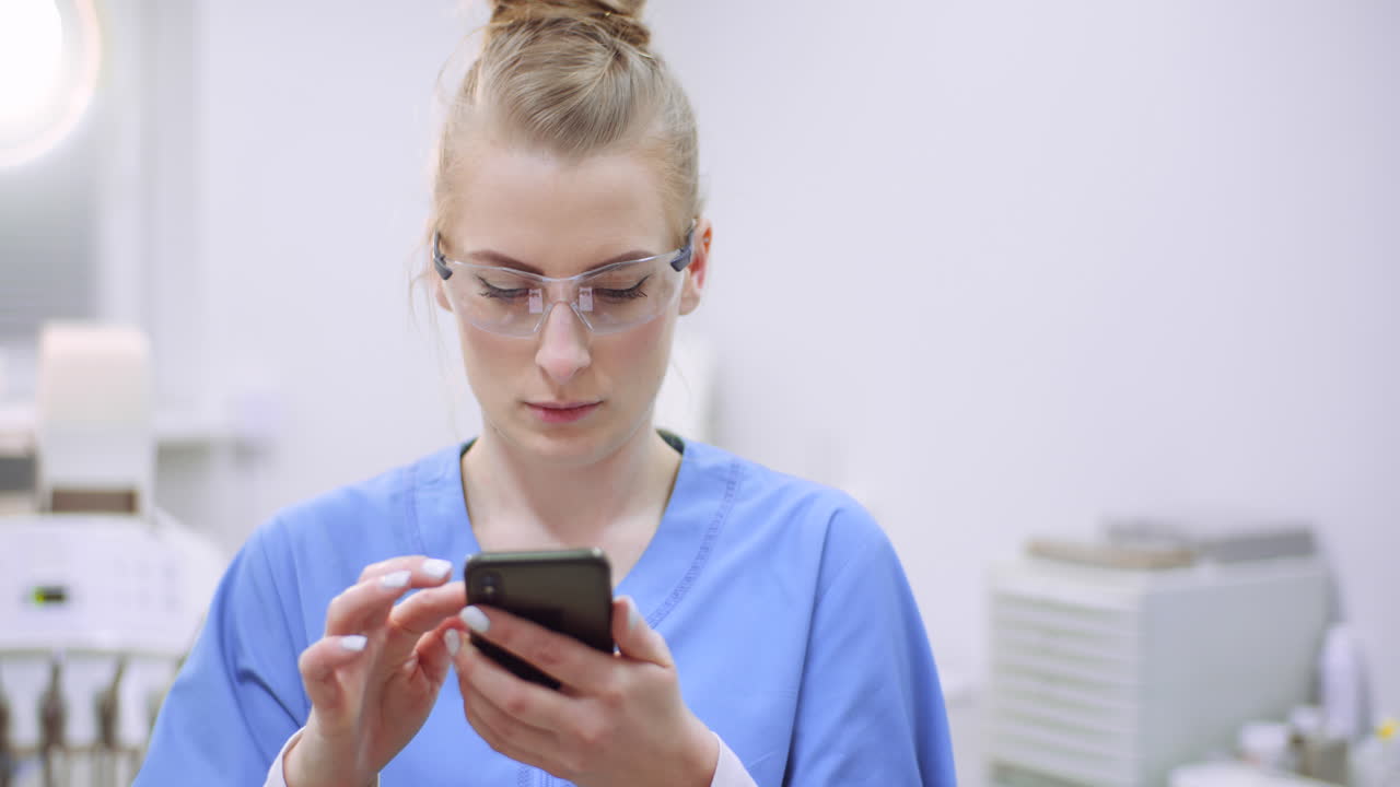 Free stock video - Female doctor using mobile at healthcare clinic 4