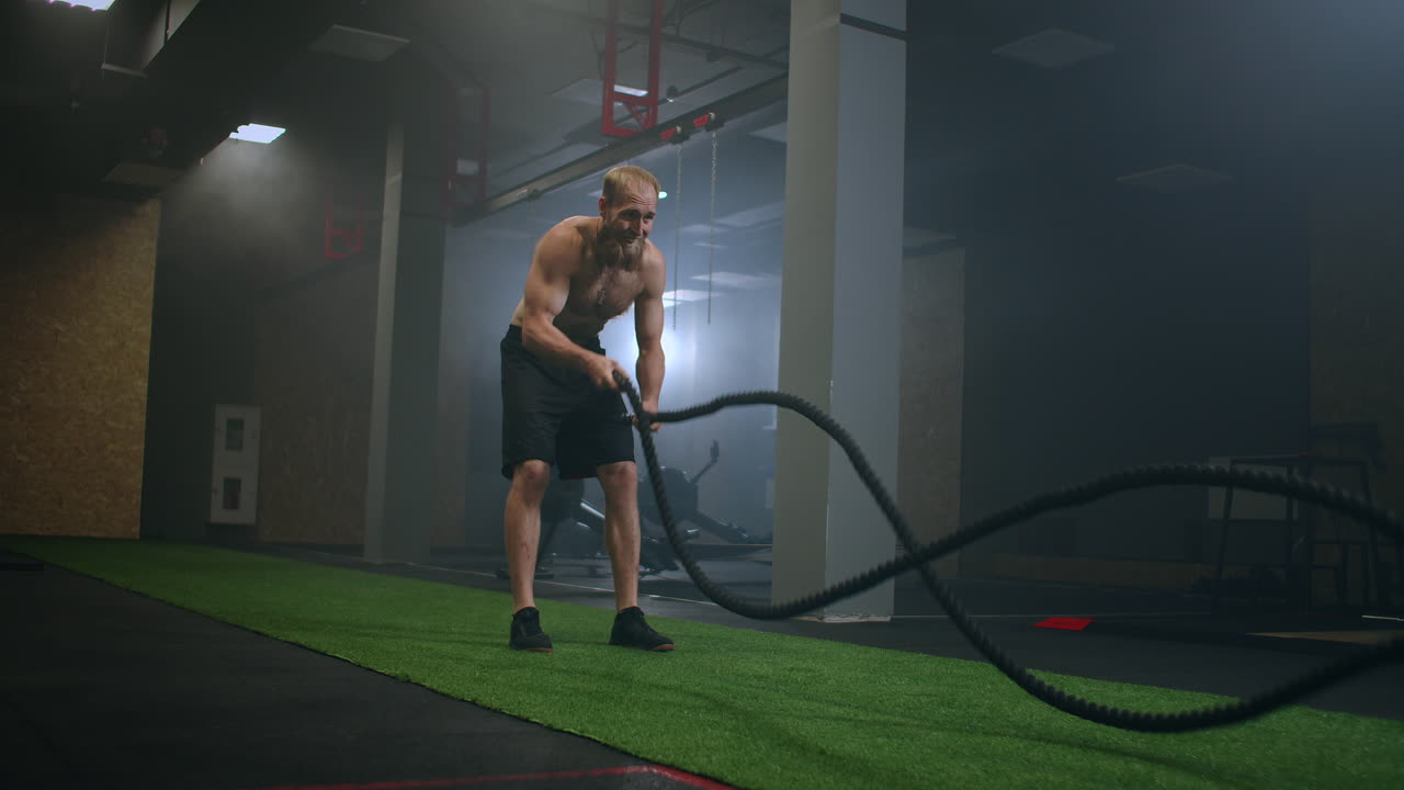 Premium stock video - Fitness athletes training using battle ropes ...