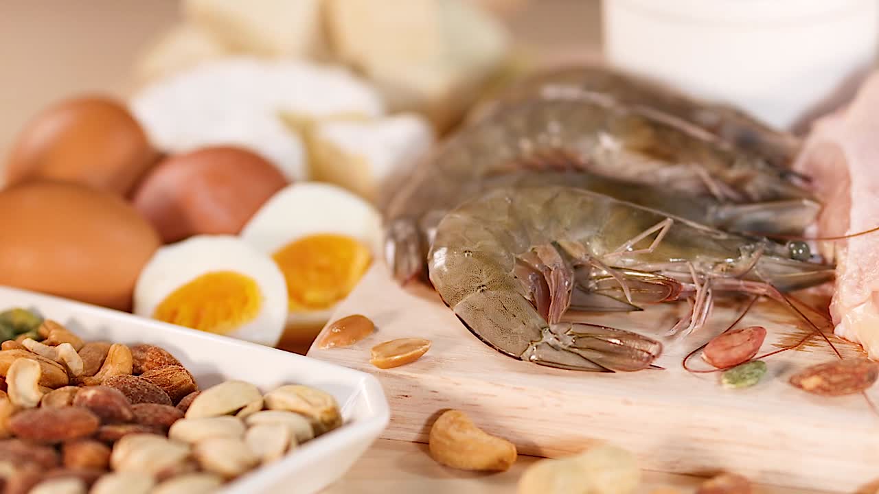 A selection of shrimp, nuts, and eggs displayed with milk and chicken ...