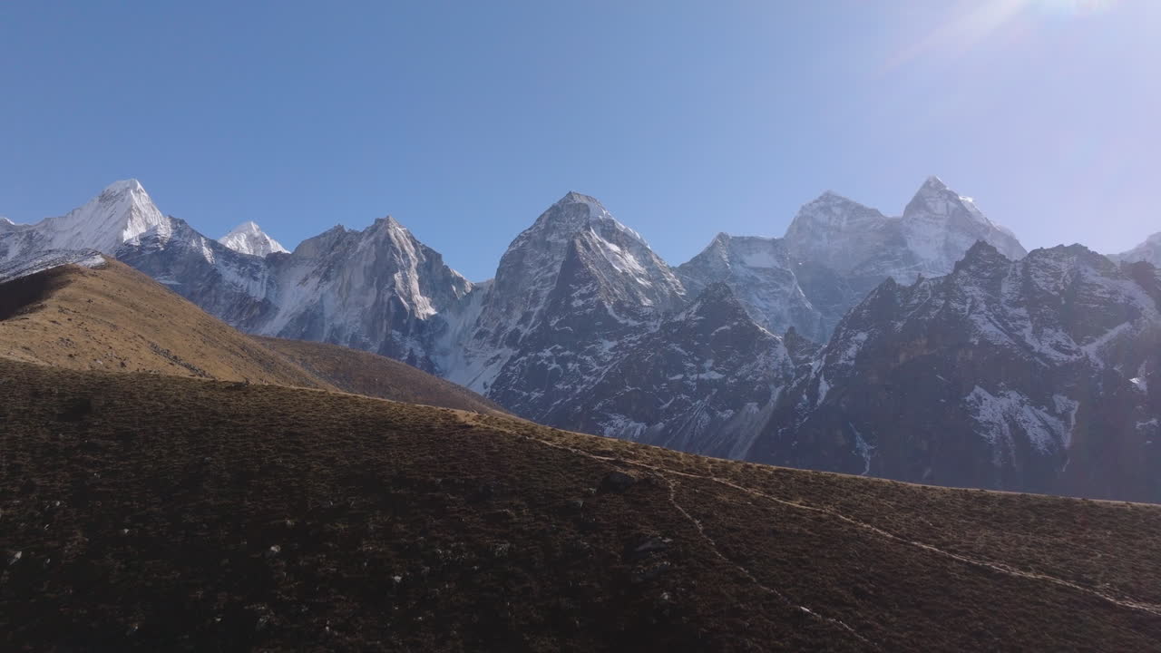 Drone soars above a hill to reveal the Himalayan range in the Everest ...