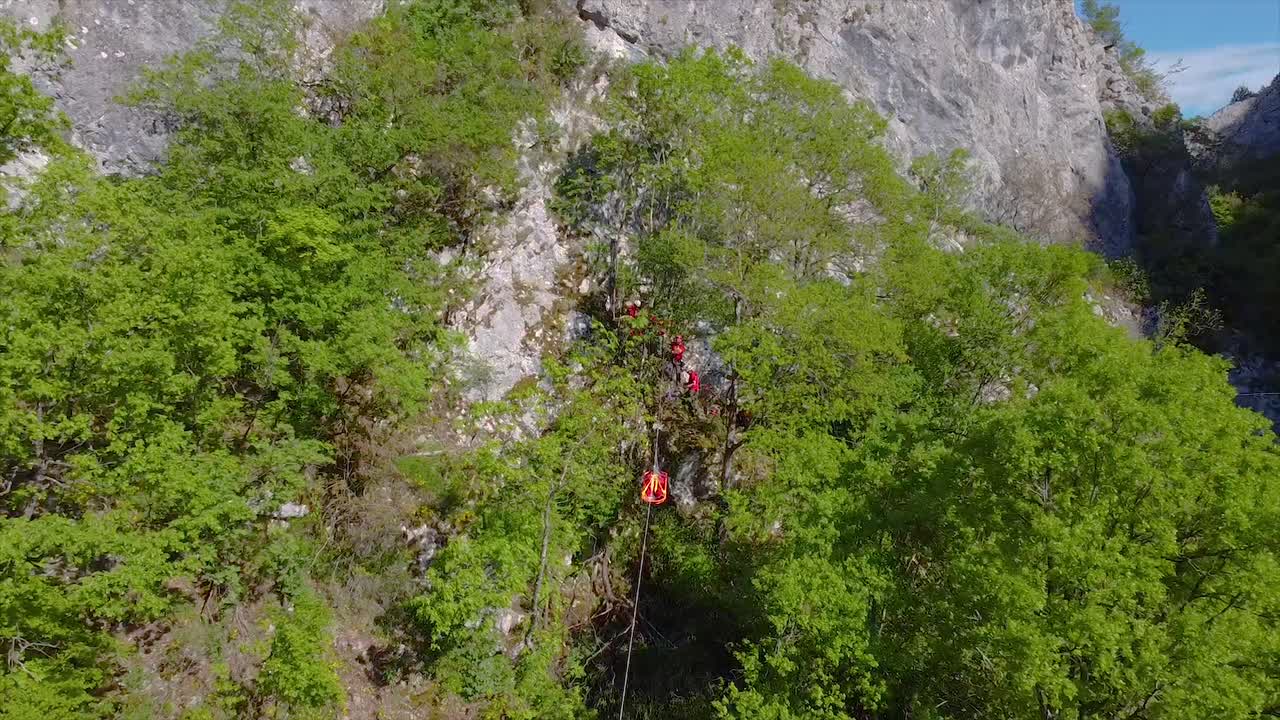 Rescue Team Transporting Emergency Stretcher On A Zip Line Drone Shot ...