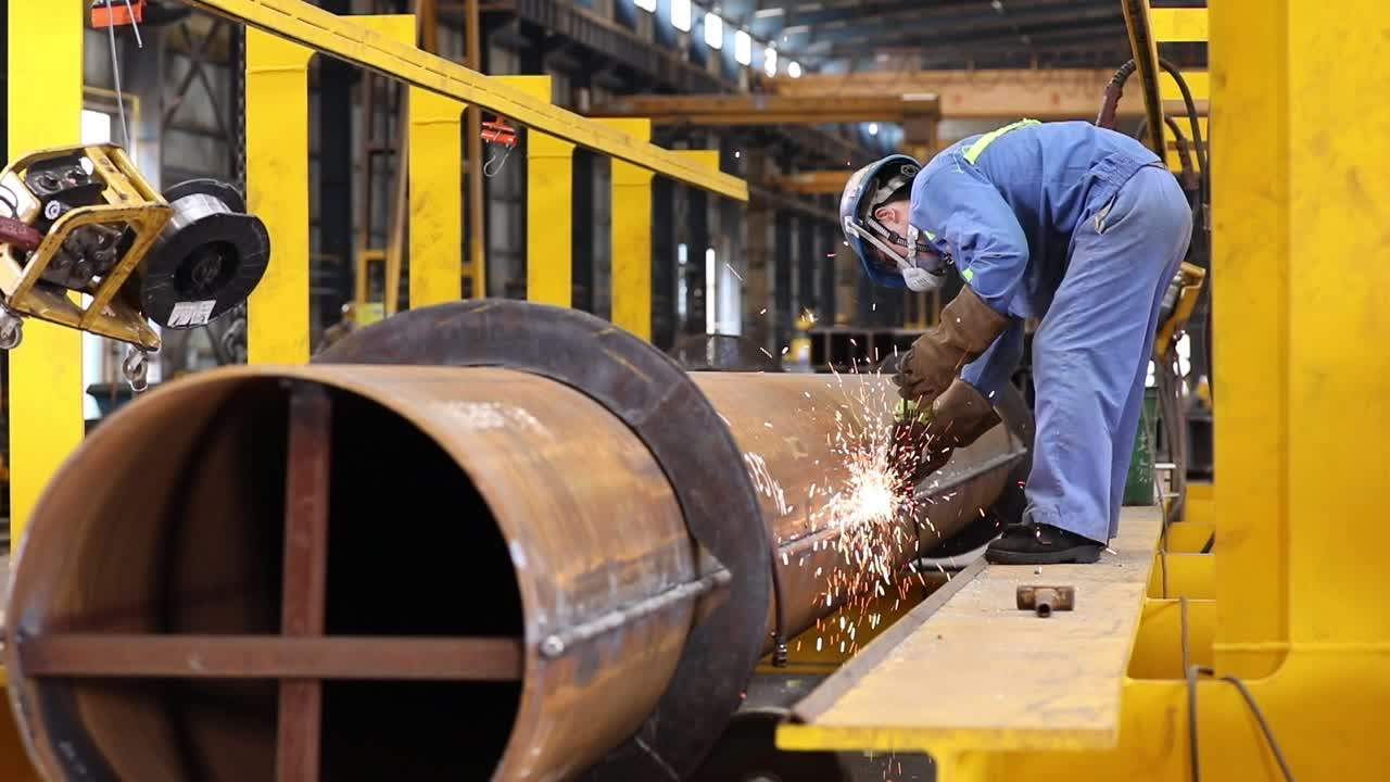 Worker Removing Weld Spots On Steel Cylindrical Column With Grinder ...