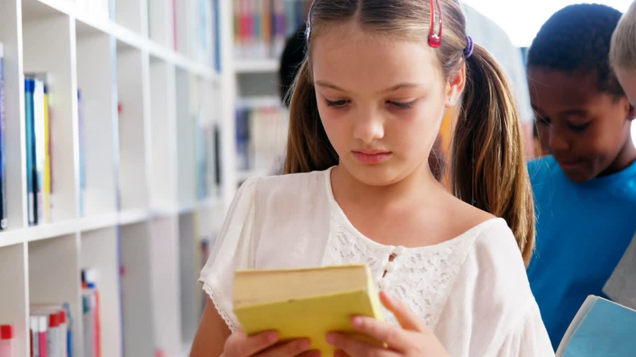 Premium stock video - Girl looking at book in library