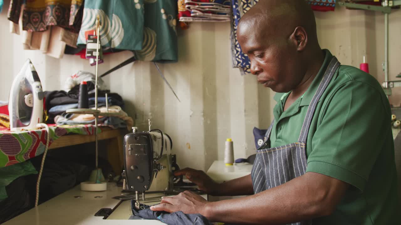 African man sewing tissue | Premium Stock Video Footage