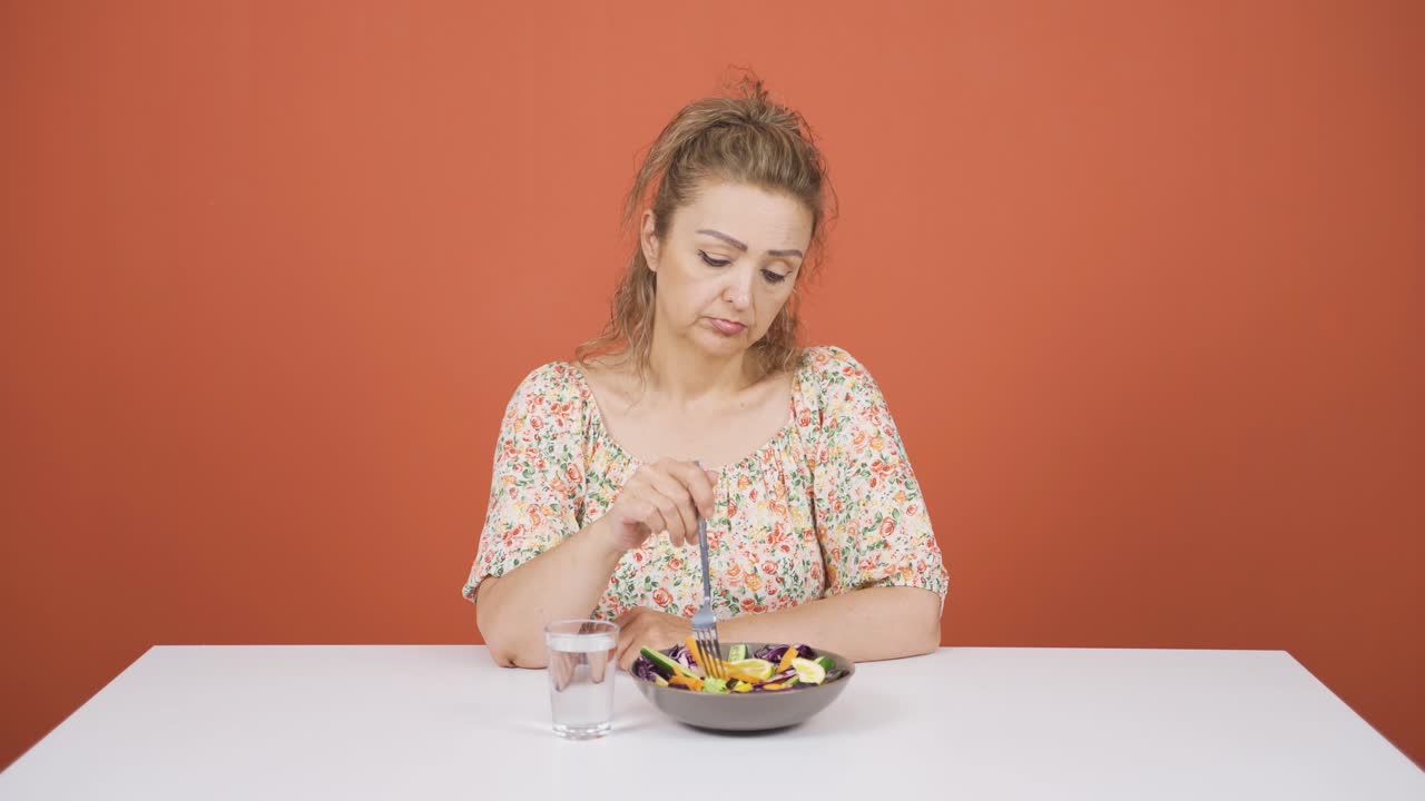 La persona que hace dieta se cansa de comer ensalada. una persona que ...