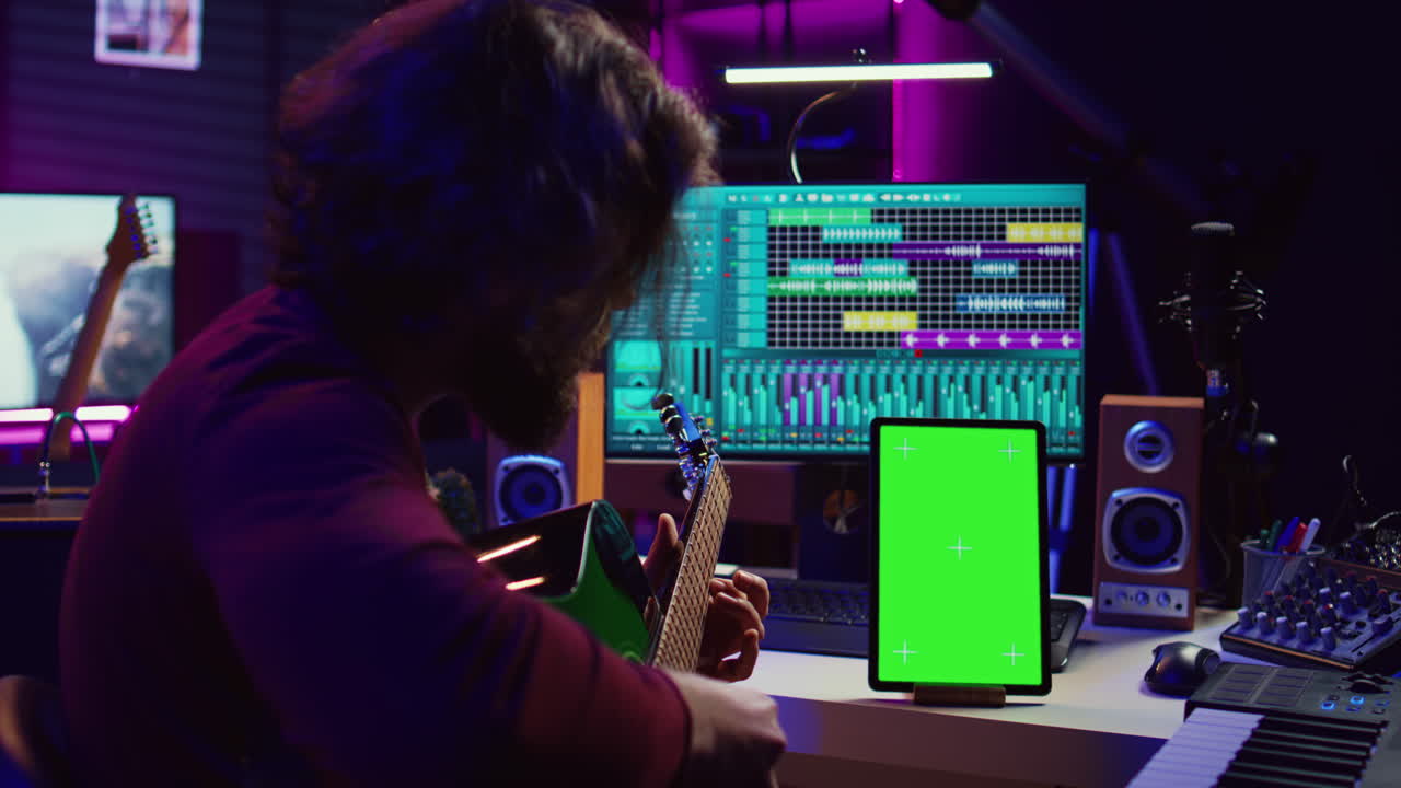 Sound engineer practices playing acoustic guitar using learning app ...