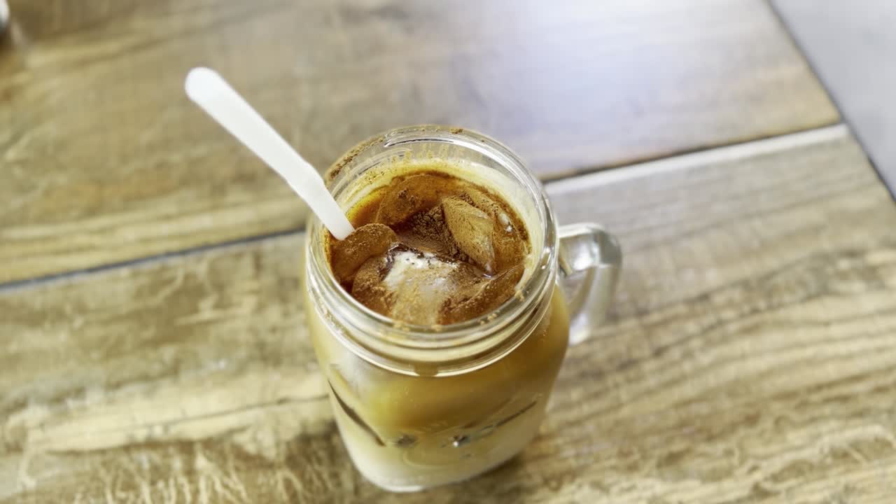 Dirty iced chai latte in a mason jar on table top, cinnamon, cacao ...