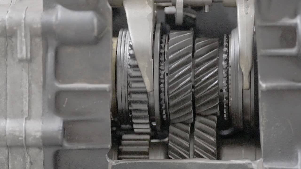 Close-up of a vehicle gearbox cutaway revealing gear train movement and ...